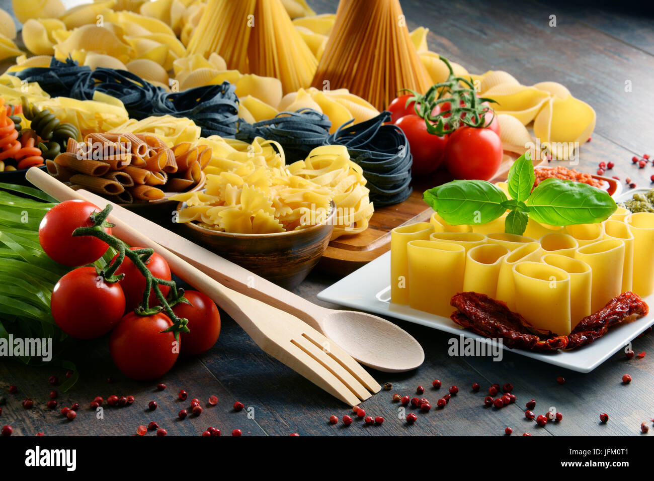 Composition with different sorts of pasta on kitchen table Stock Photo ...