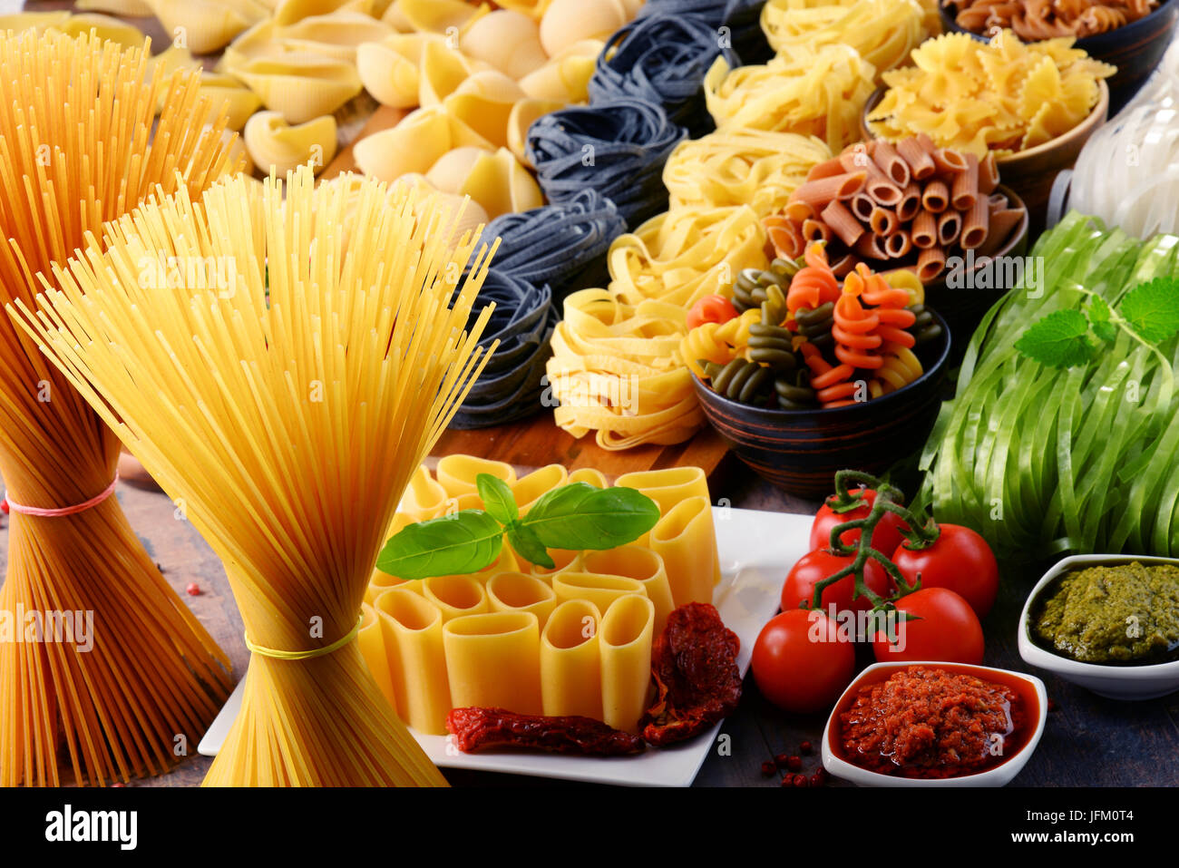 Composition with different sorts of pasta on kitchen table Stock Photo ...