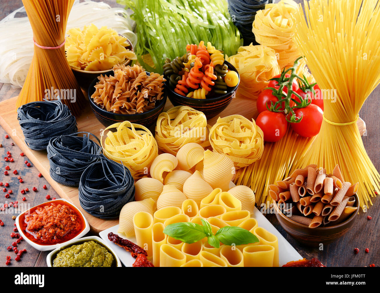 Composition with different sorts of pasta on kitchen table Stock Photo ...