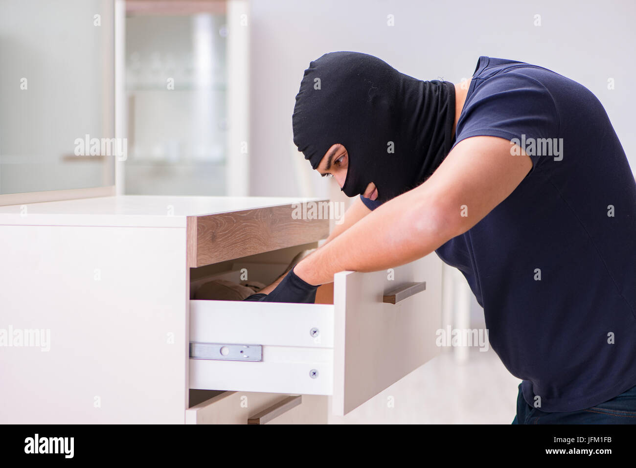 Robber wearing balaclava stealing valuable things Stock Photo - Alamy