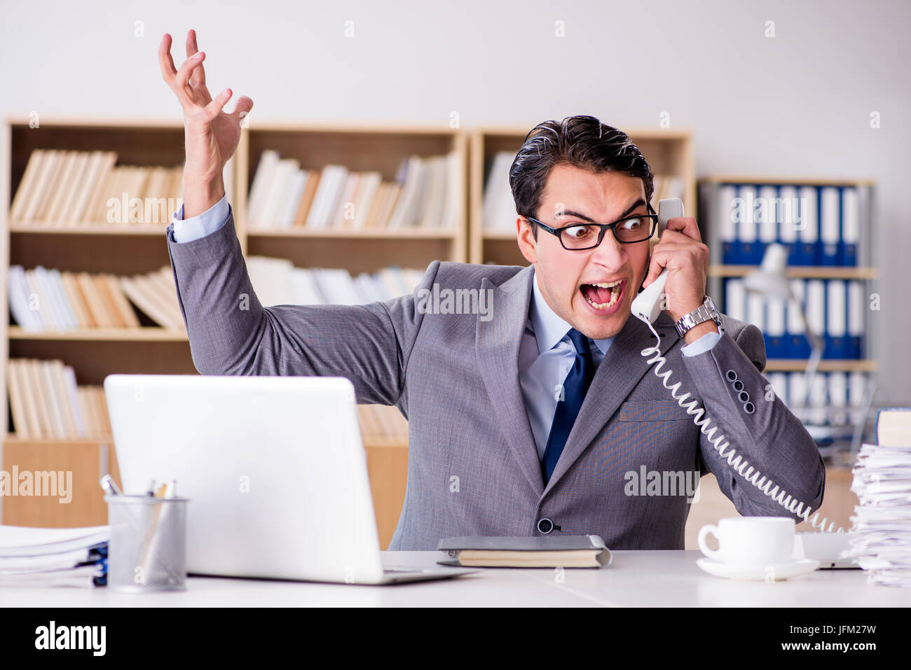 Angry businessman with too much work in office Stock Photo - Alamy