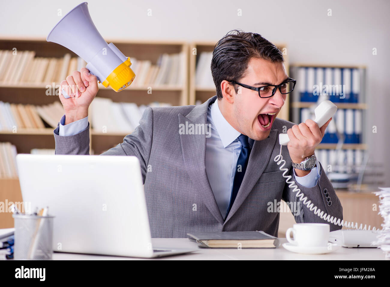 Angry businessman with too much work in office Stock Photo - Alamy