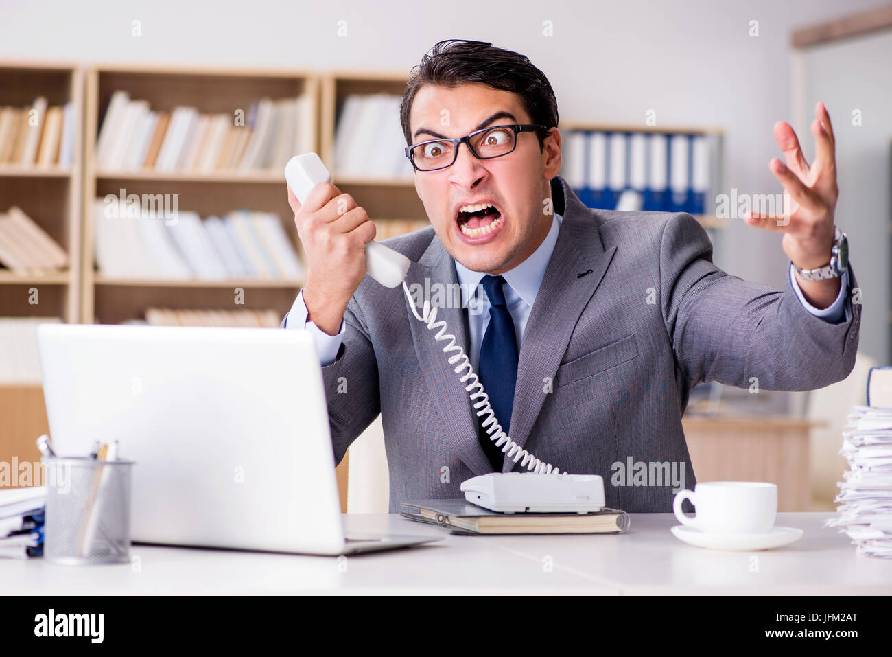 Angry businessman with too much work in office Stock Photo - Alamy