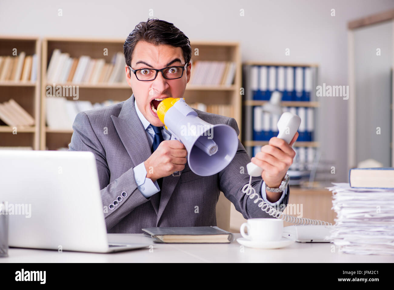 Angry businessman with too much work in office Stock Photo - Alamy