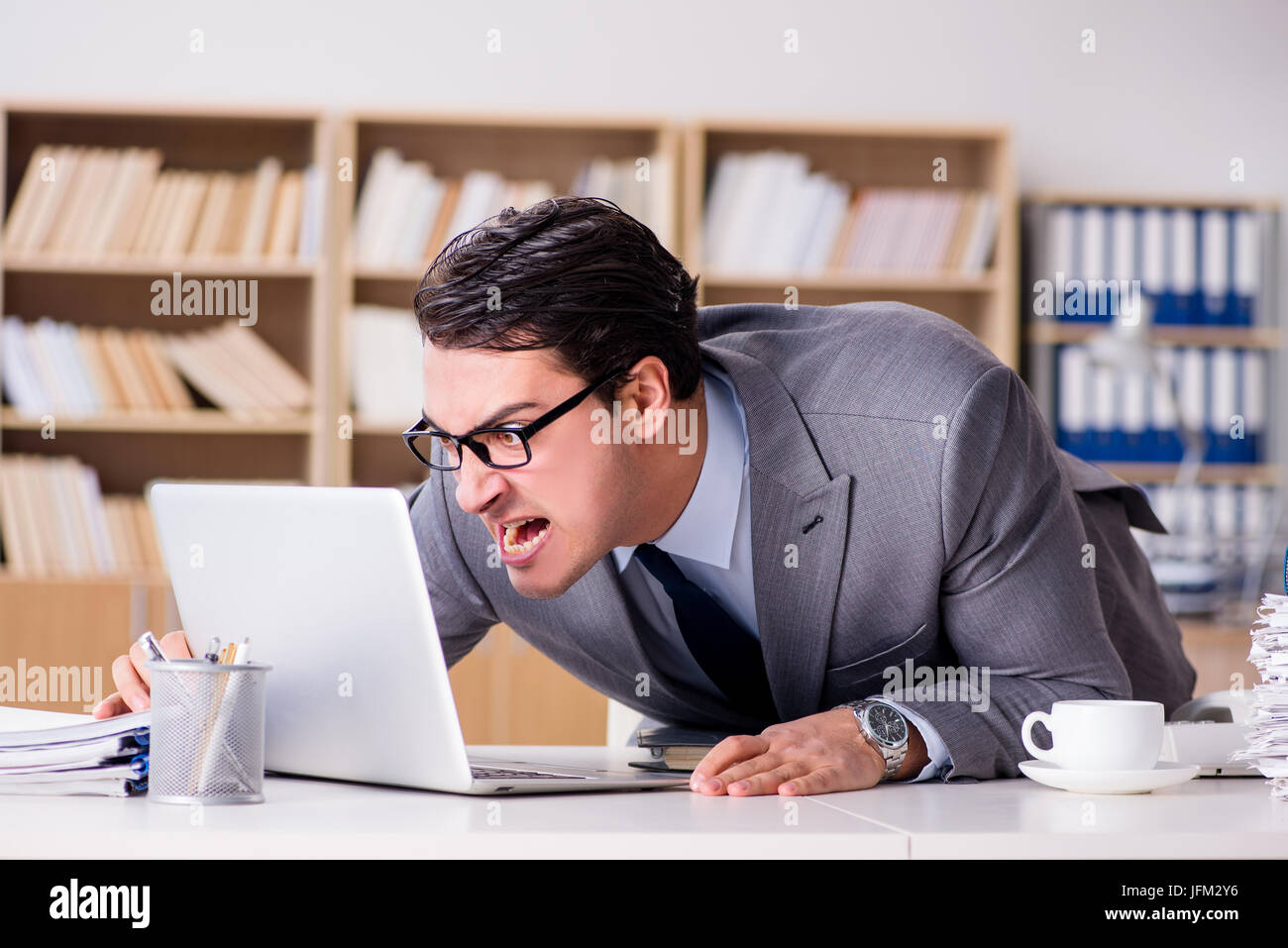 Angry businessman with too much work in office Stock Photo - Alamy