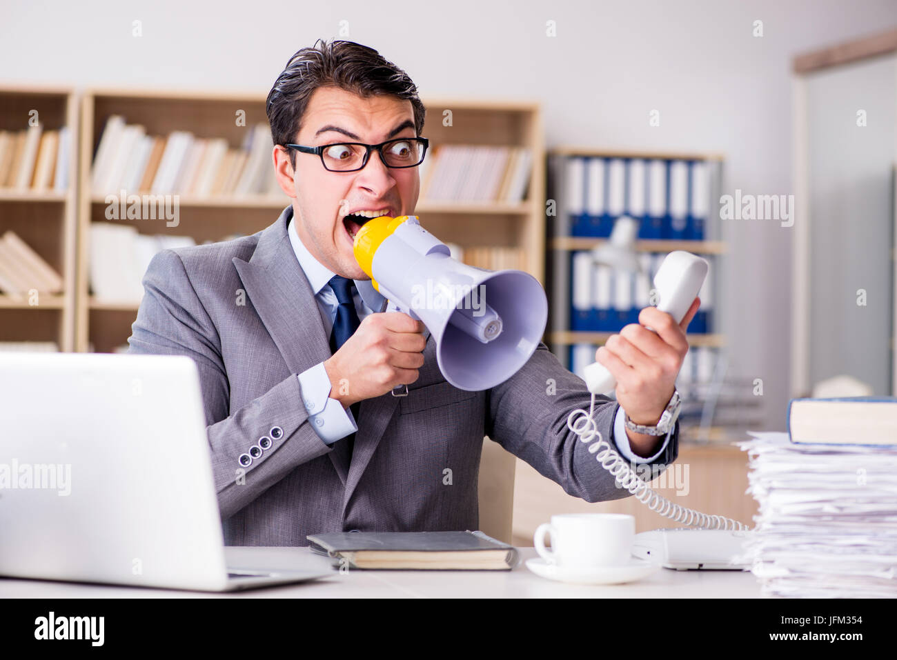 Angry businessman with too much work in office Stock Photo - Alamy