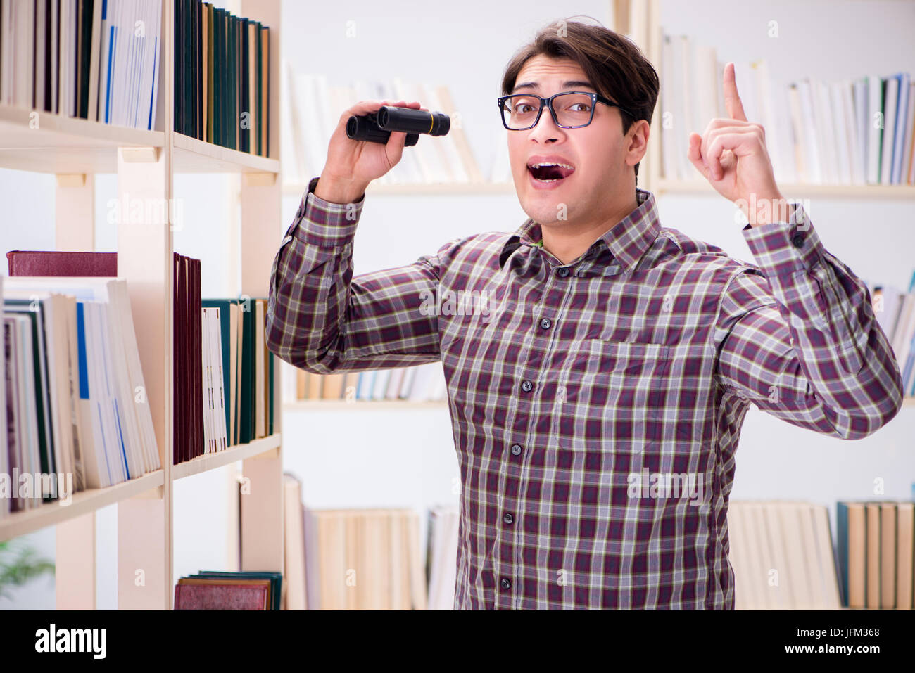 Young student looking for books in college library Stock Photo - Alamy