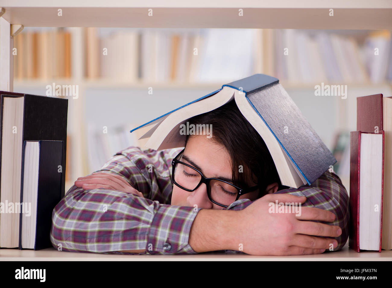 Young student looking for books in college library Stock Photo - Alamy