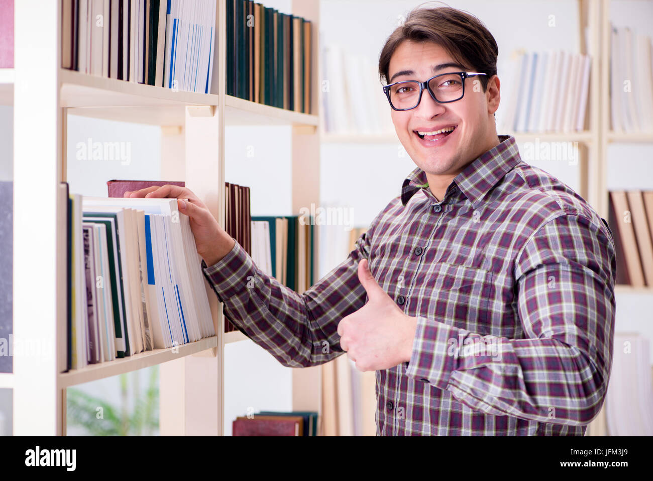 Young student looking for books in college library Stock Photo - Alamy
