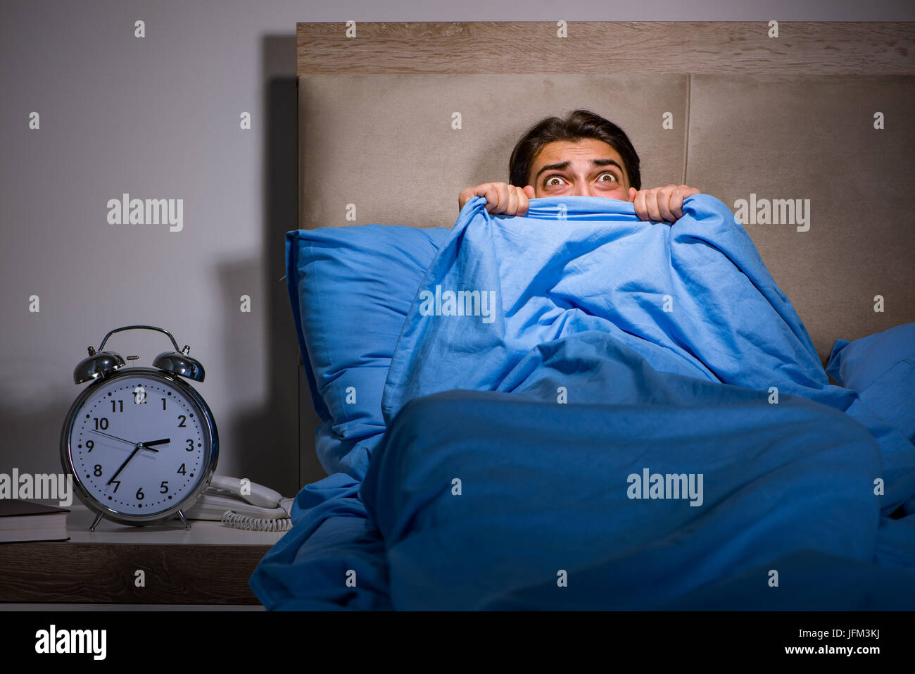 Young man scared in bed Stock Photo - Alamy