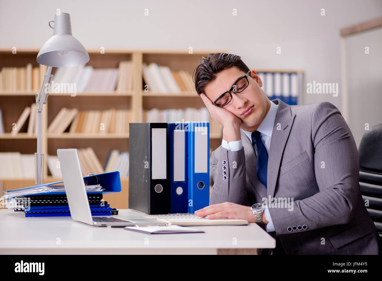 Sleepy businessman working in office Stock Photo - Alamy