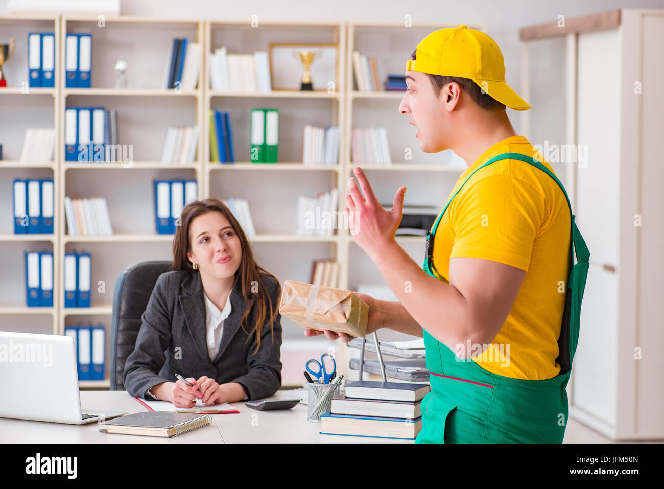 Postman delivering parcel to the office Stock Photo - Alamy