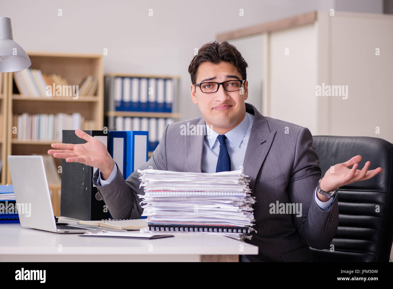 Businessman struggling with stacks of papers Stock Photo - Alamy