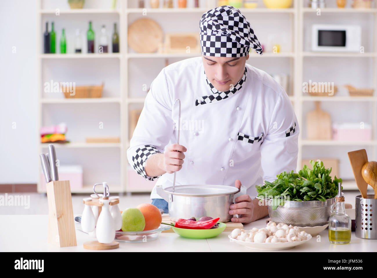 Young male cook working in the kitchen Stock Photo - Alamy