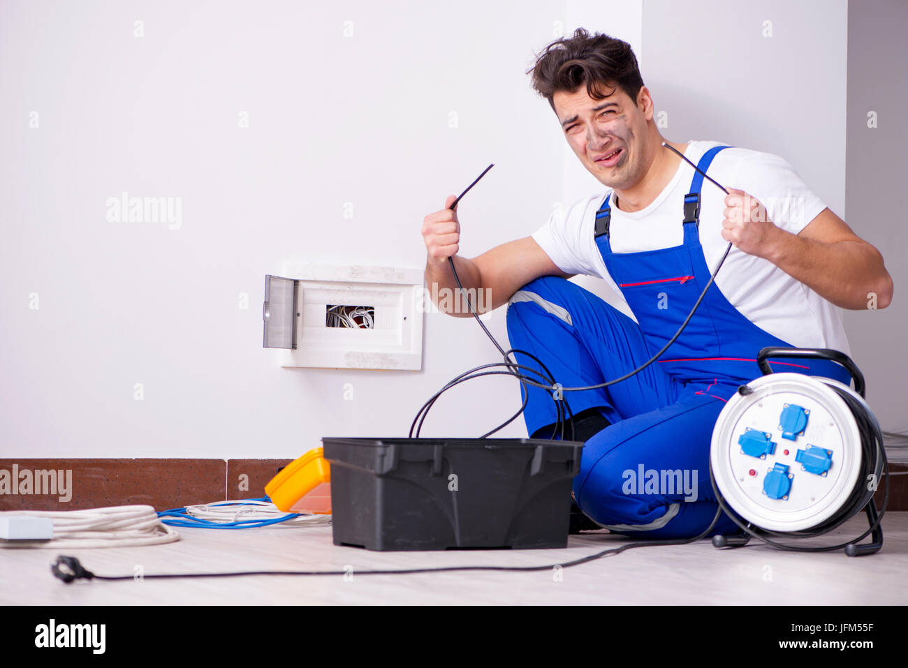 Funny Man doing electrical repairs at home Stock Photo - Alamy