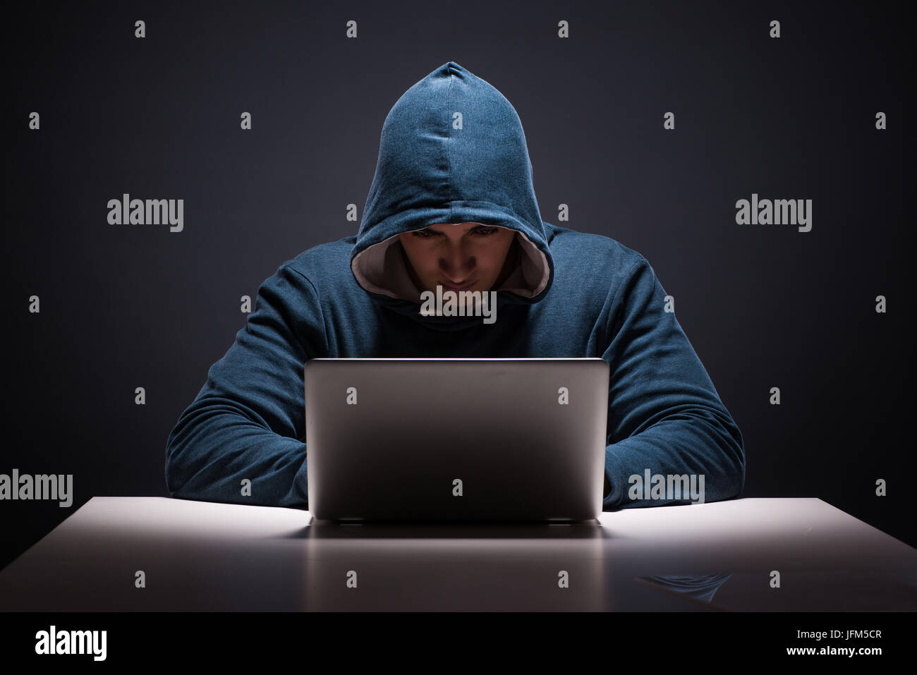Computer hacker working in dark room Stock Photo - Alamy