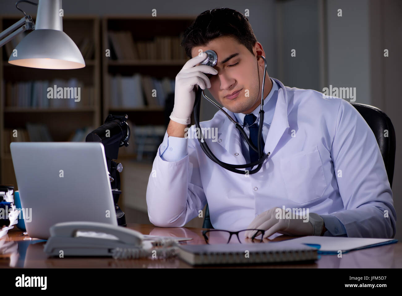 Young doctor working late in the office Stock Photo - Alamy