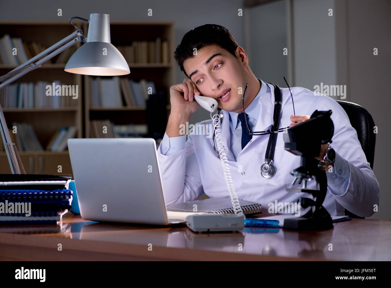 Young doctor working late in the office Stock Photo - Alamy