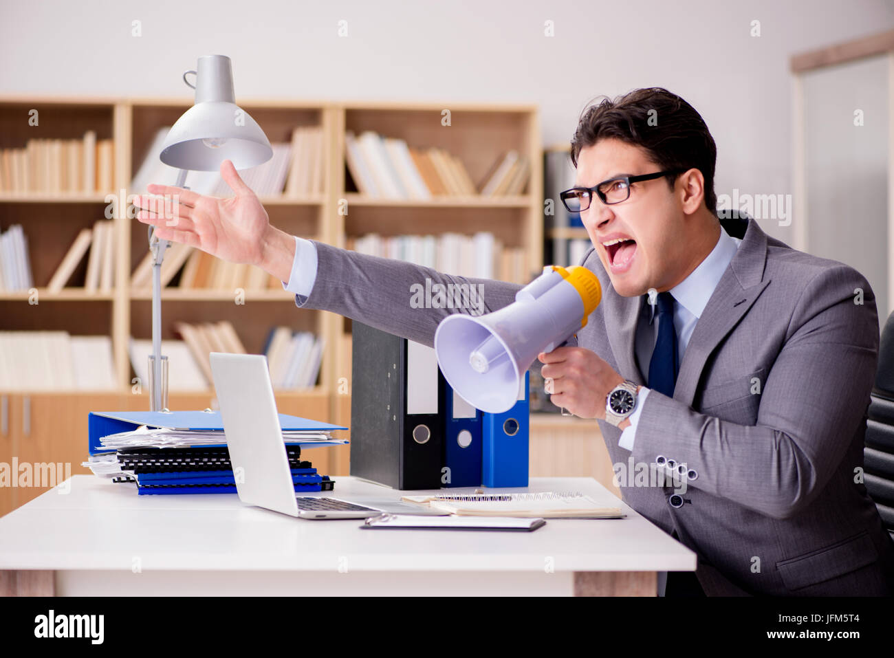 Businessman with loudspeaker megaphone in office Stock Photo - Alamy