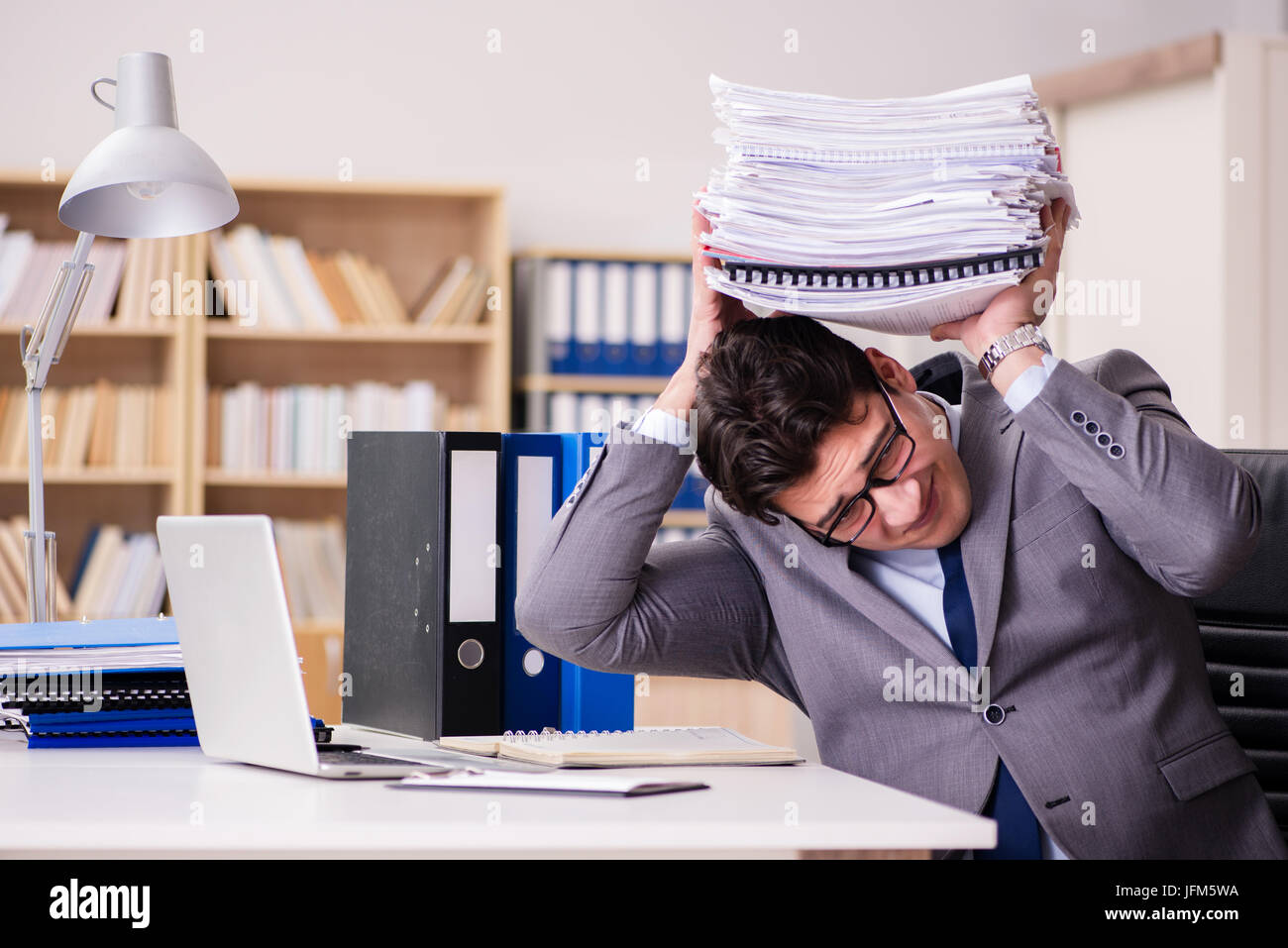 Businessman struggling with stacks of papers Stock Photo - Alamy