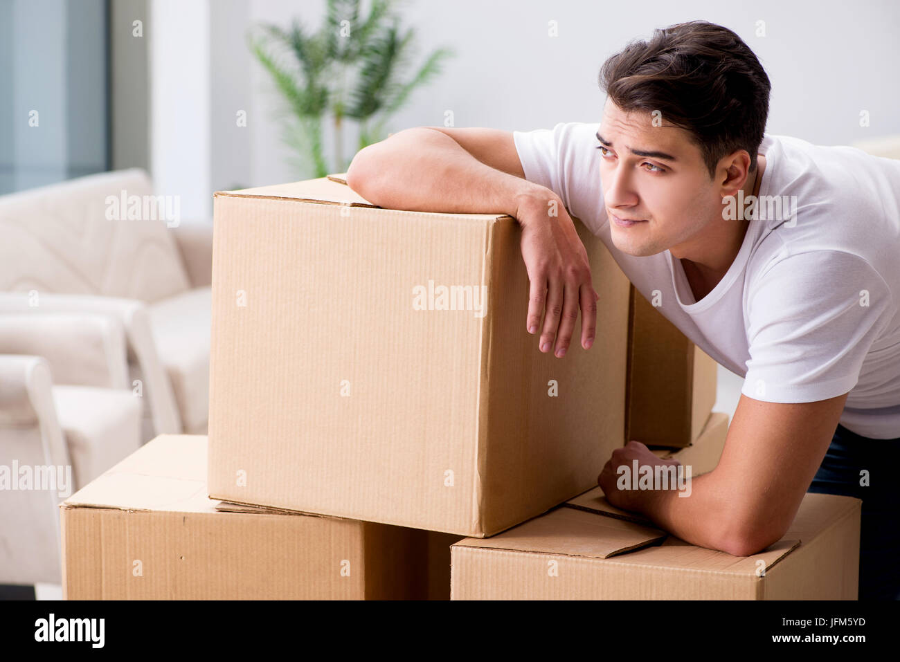 Young man moving boxes at home Stock Photo - Alamy
