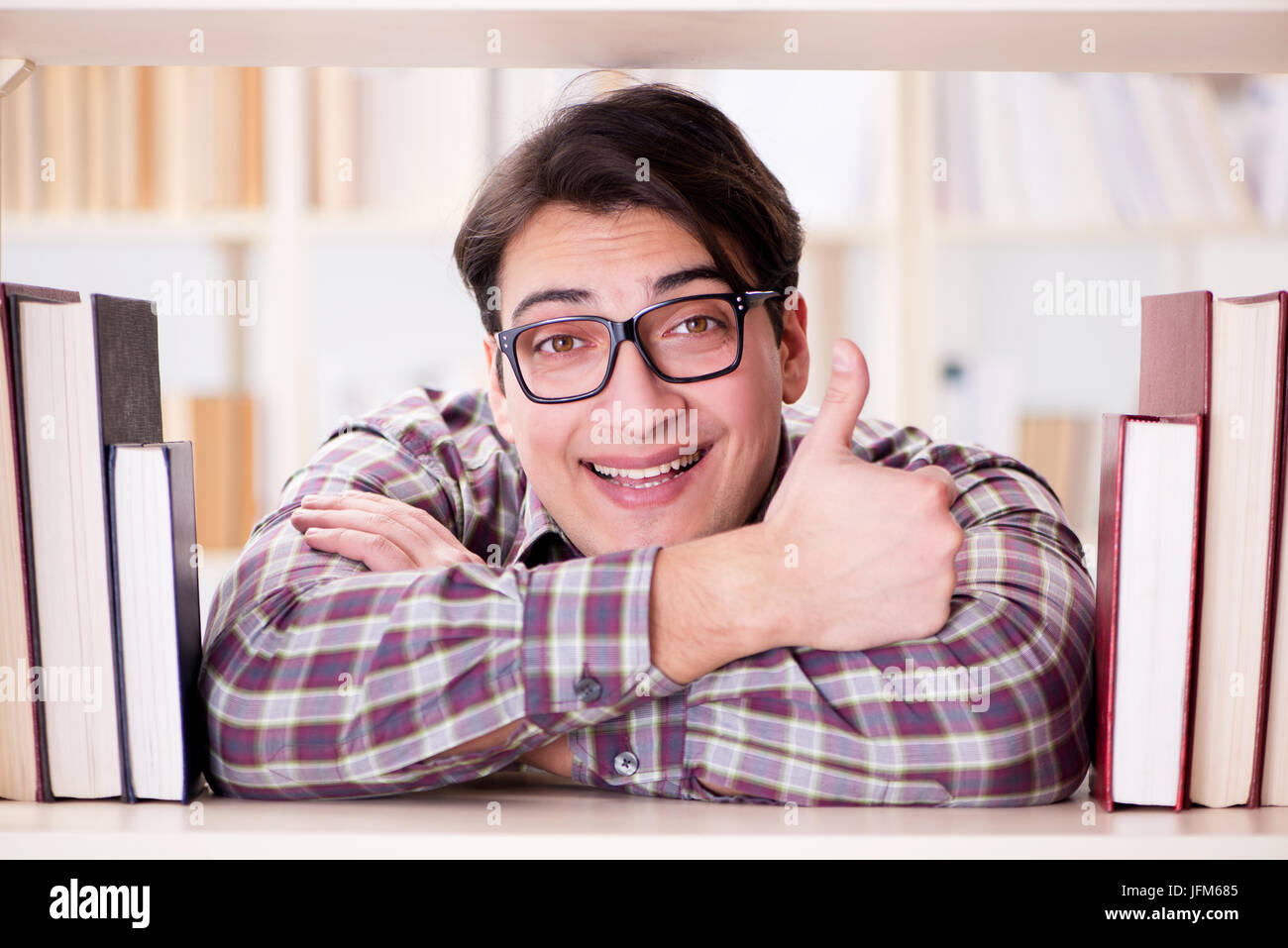 Young student looking for books in college library Stock Photo - Alamy