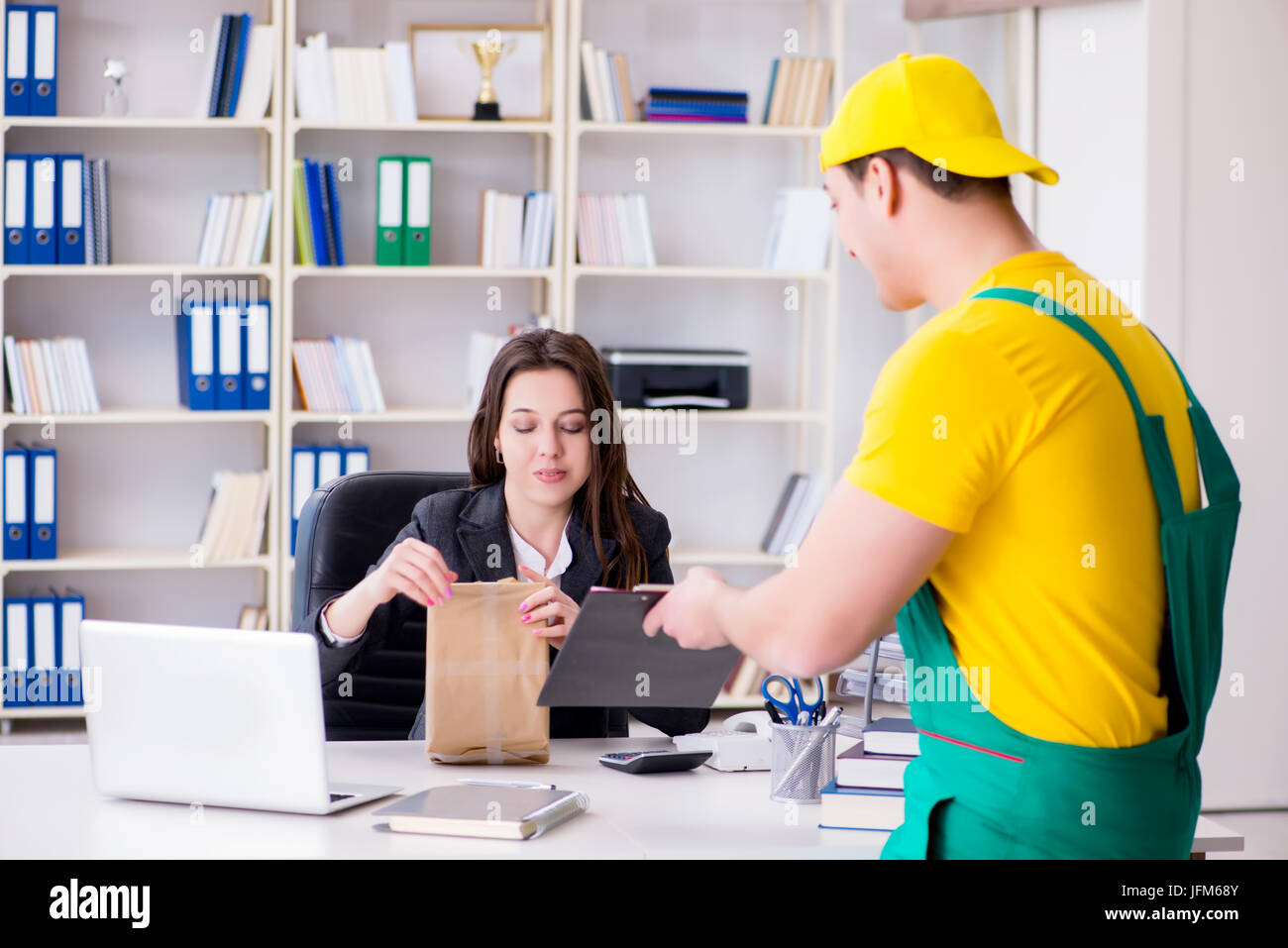 Postman delivering parcel to the office Stock Photo - Alamy