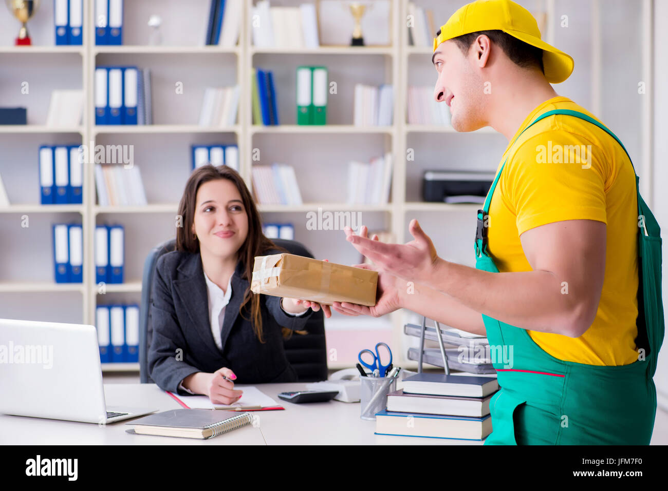 Postman delivering parcel to the office Stock Photo - Alamy