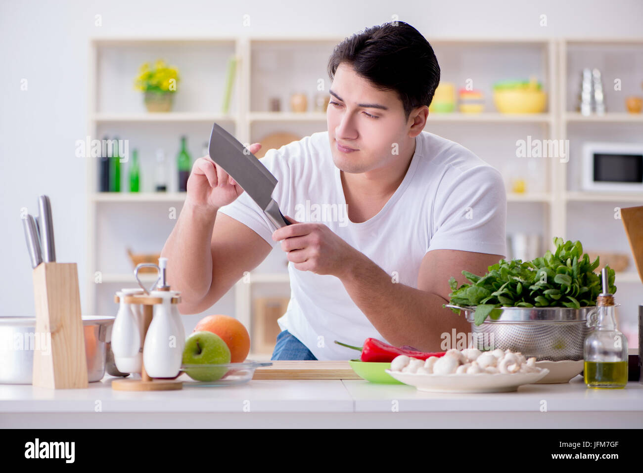Young male cook working in the kitchen Stock Photo - Alamy