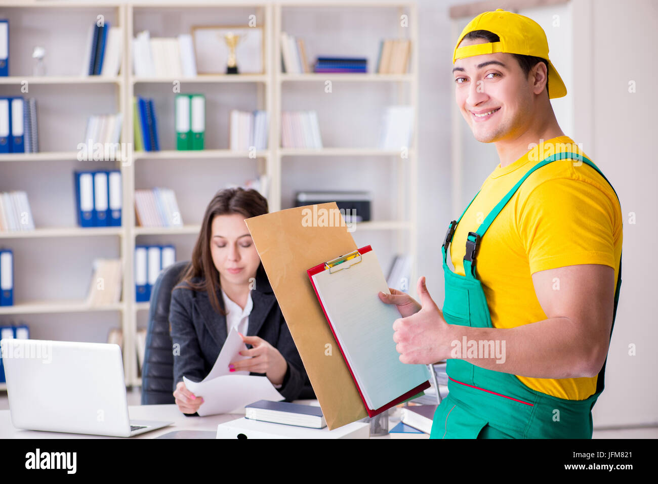 Postman delivering parcel to the office Stock Photo - Alamy