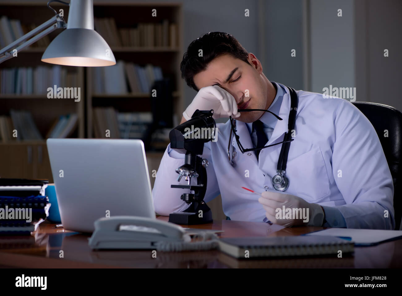 Young doctor working late in the office Stock Photo - Alamy
