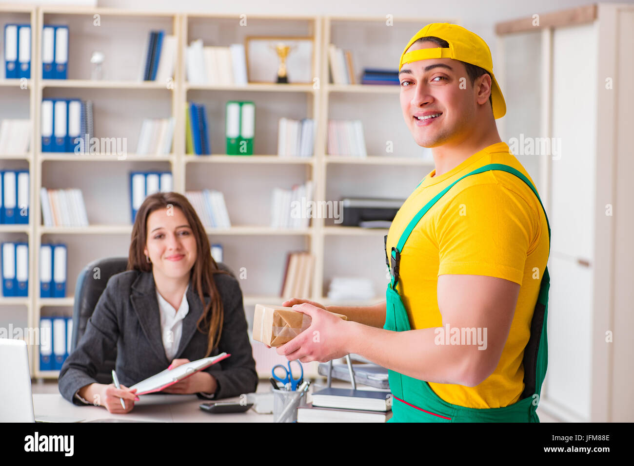 Postman delivering parcel to the office Stock Photo - Alamy
