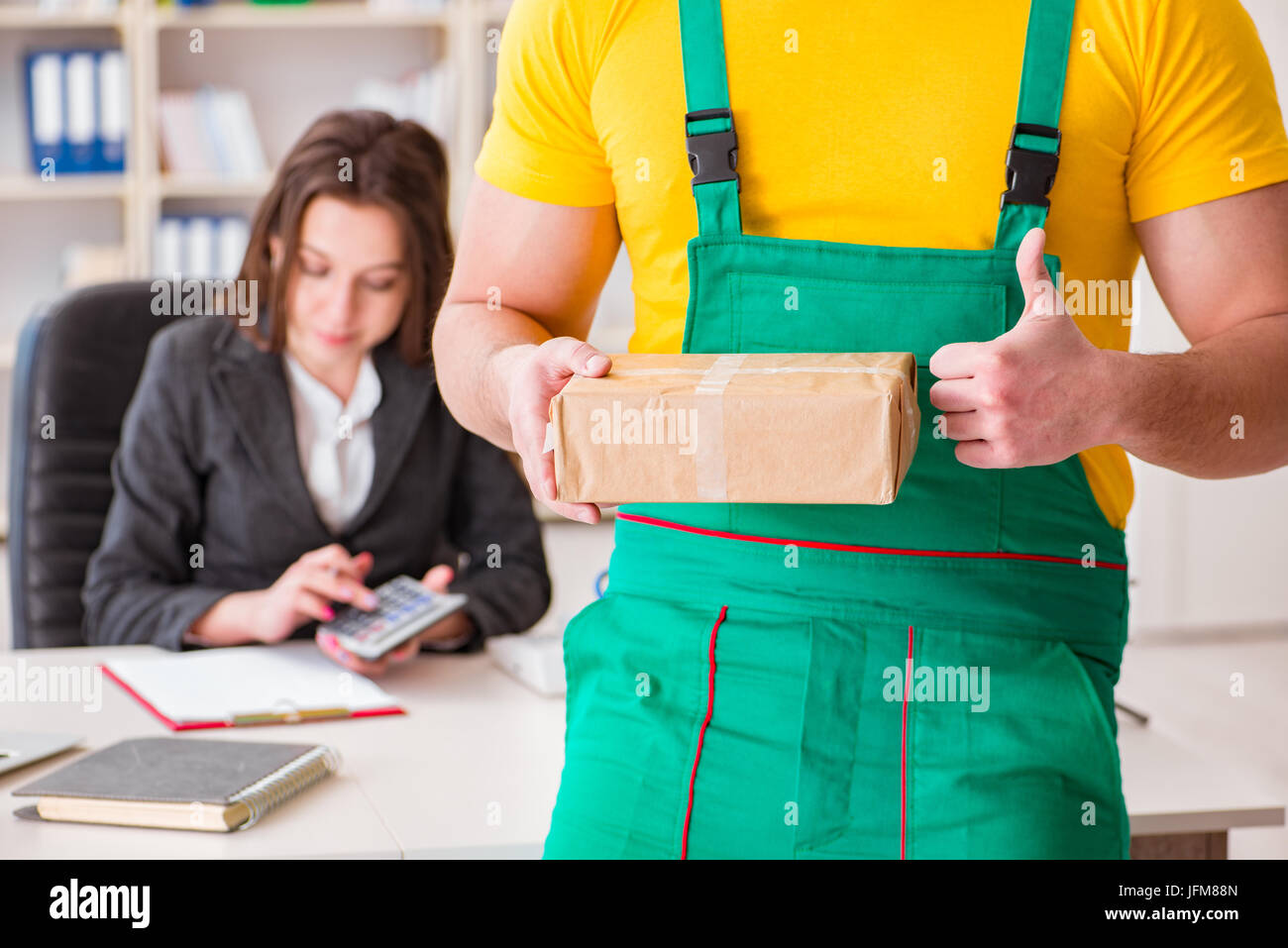 Postman delivering parcel to the office Stock Photo - Alamy
