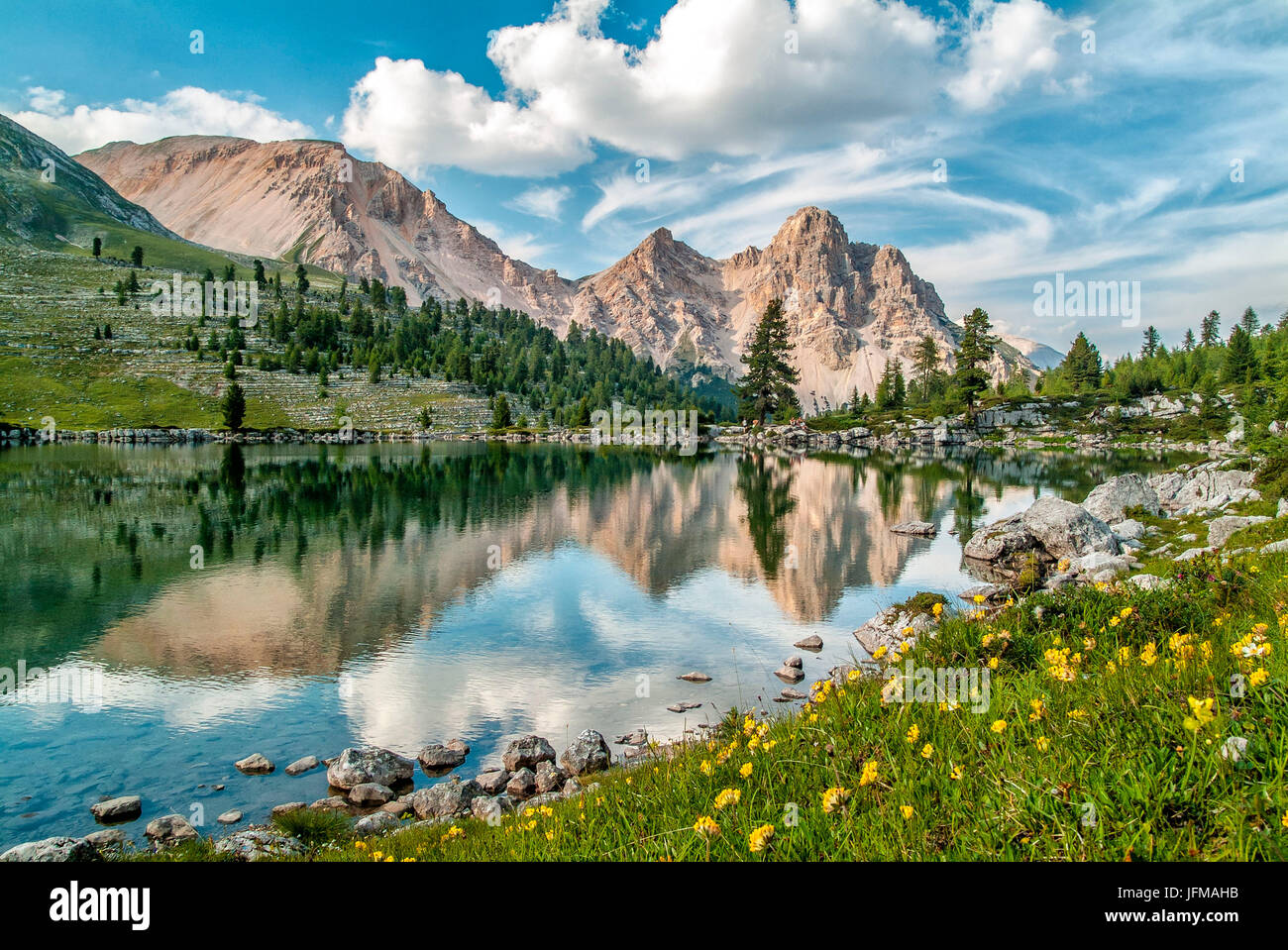 The calm water of the Lake Verde reflecting the Dolomite peaks of the ...