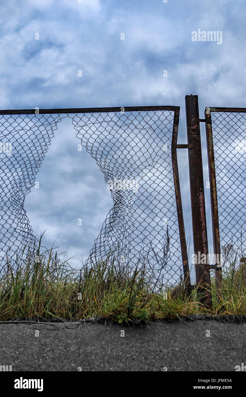 Symbol / Concepts, Iron fence with a large hole Stock Photo - Alamy