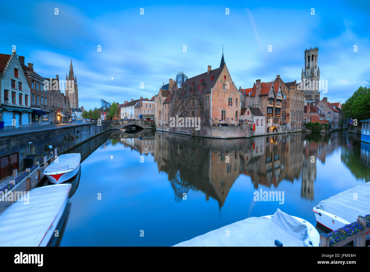 The medieval Belfry and historic buildings are reflected in ...