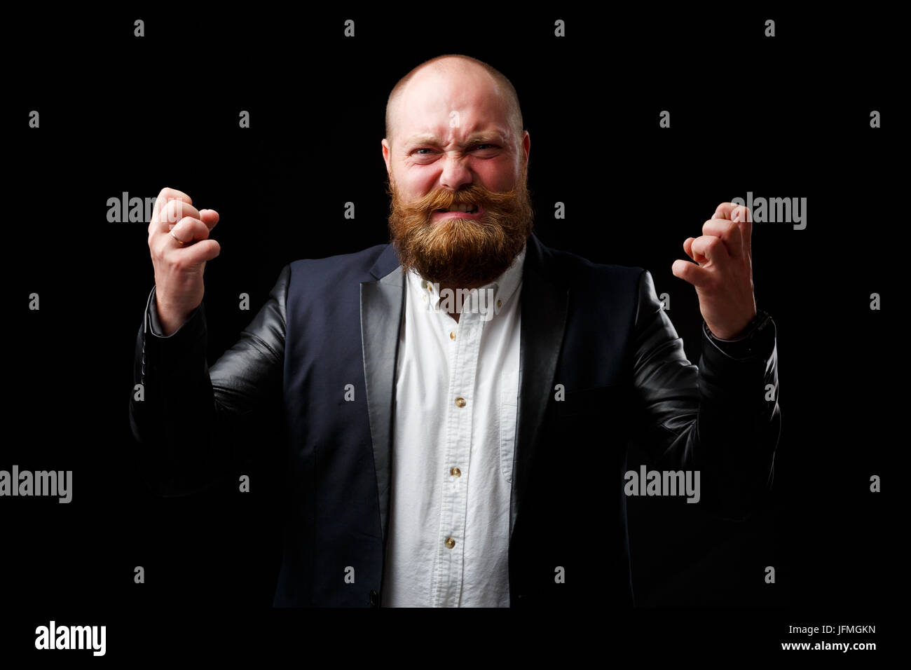 Evil man with tense hands with ginger beard and mustache on empty black ...