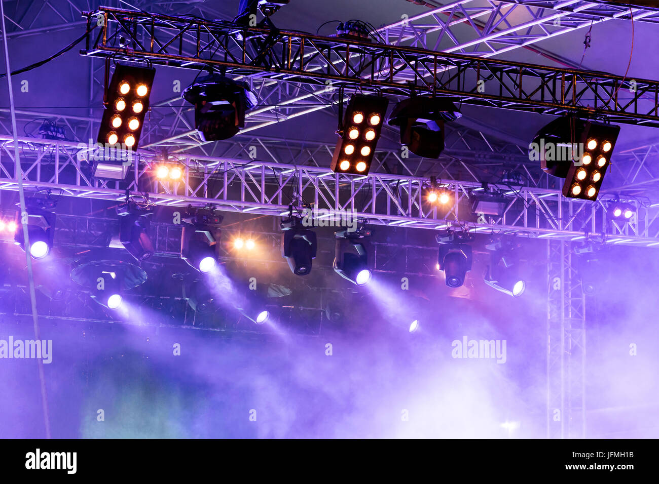 smoky stage illuminated with blue spot lightning system during rock ...