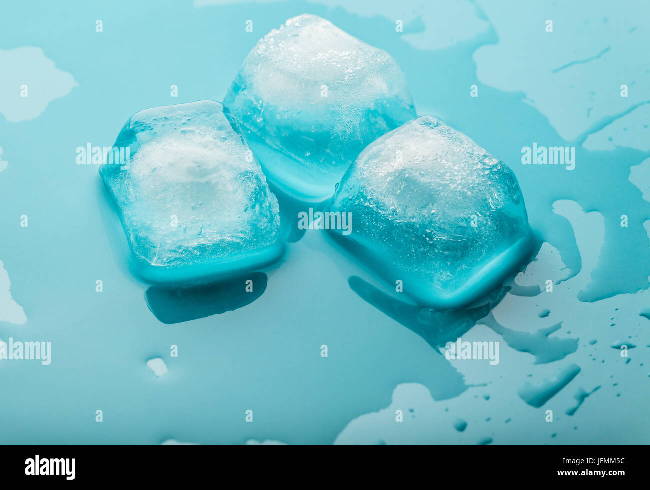 Ice cubes close-up melting on blue background Stock Photo - Alamy