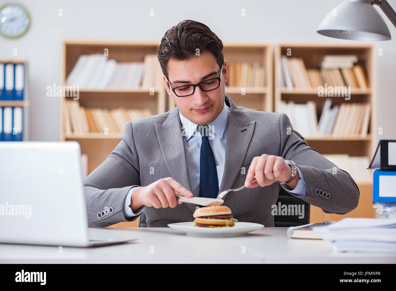 Hungry funny businessman eating junk food sandwich Stock Photo - Alamy