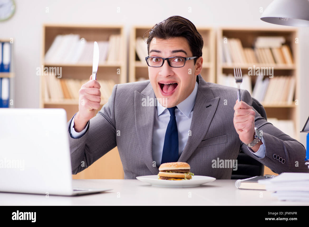 Hungry funny businessman eating junk food sandwich Stock Photo - Alamy