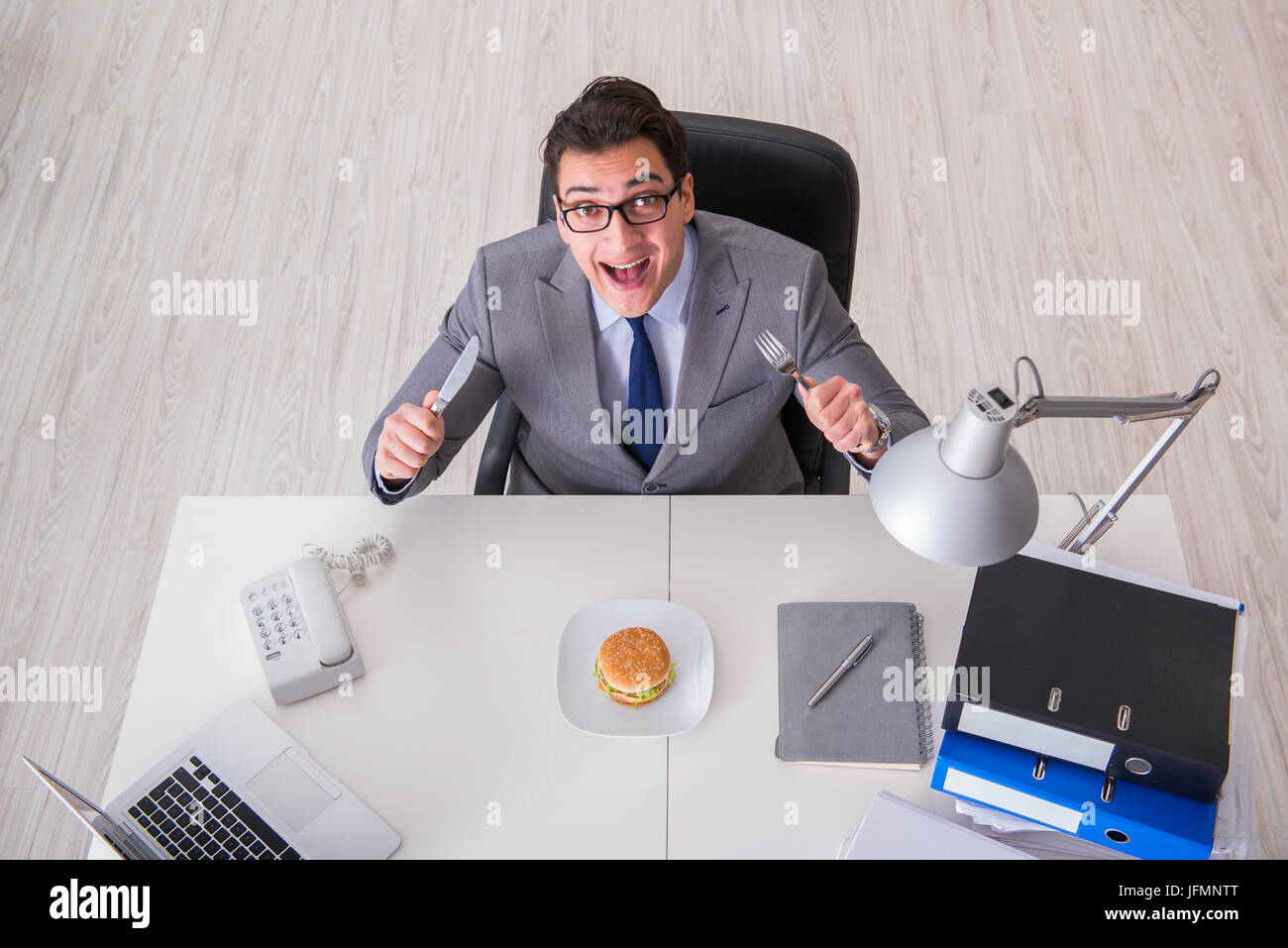 Hungry funny businessman eating junk food sandwich Stock Photo - Alamy