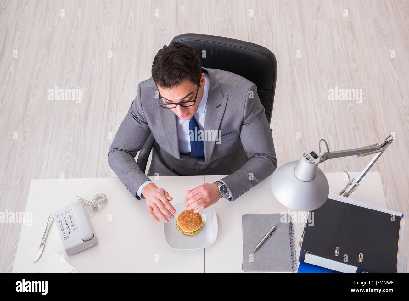 Hungry funny businessman eating junk food sandwich Stock Photo - Alamy