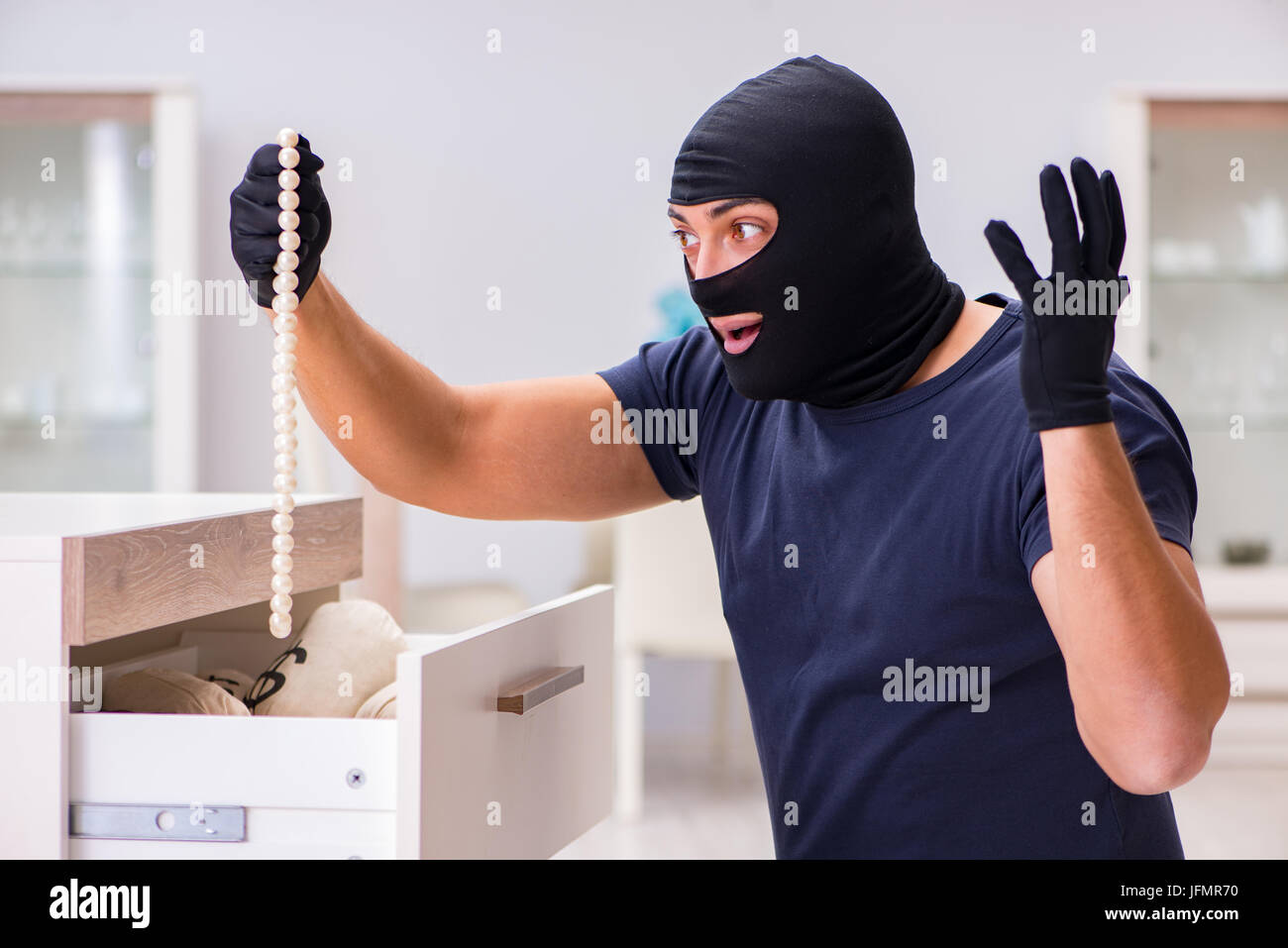 Robber wearing balaclava stealing valuable things Stock Photo - Alamy
