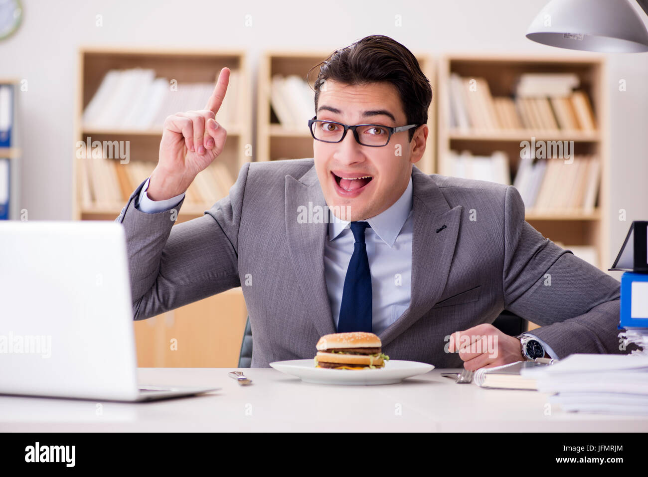 Hungry funny businessman eating junk food sandwich Stock Photo - Alamy