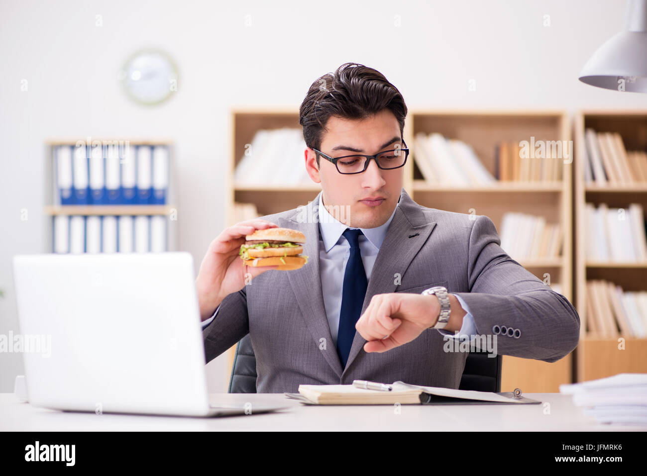 Hungry funny businessman eating junk food sandwich Stock Photo - Alamy