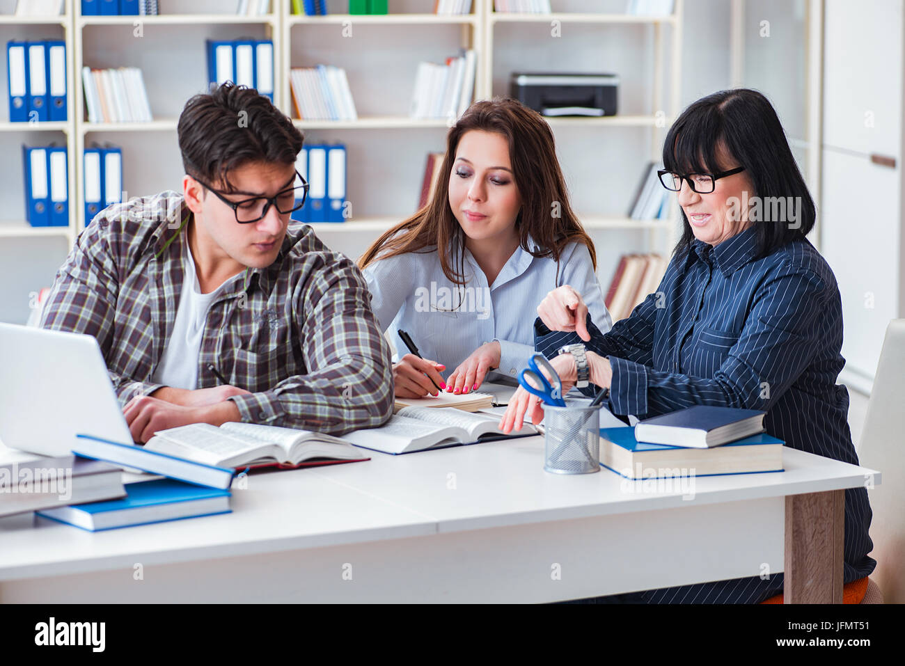 Young student and teacher during tutoring lesson Stock Photo - Alamy