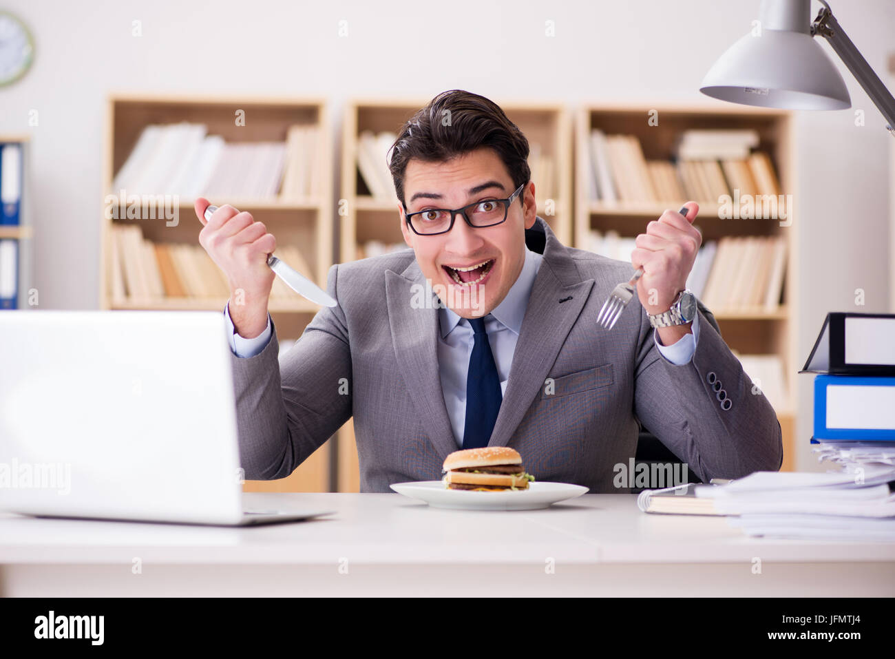 Hungry funny businessman eating junk food sandwich Stock Photo - Alamy