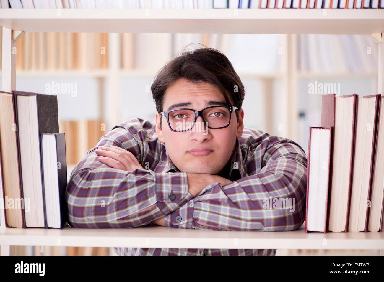 Young student looking for books in college library Stock Photo - Alamy