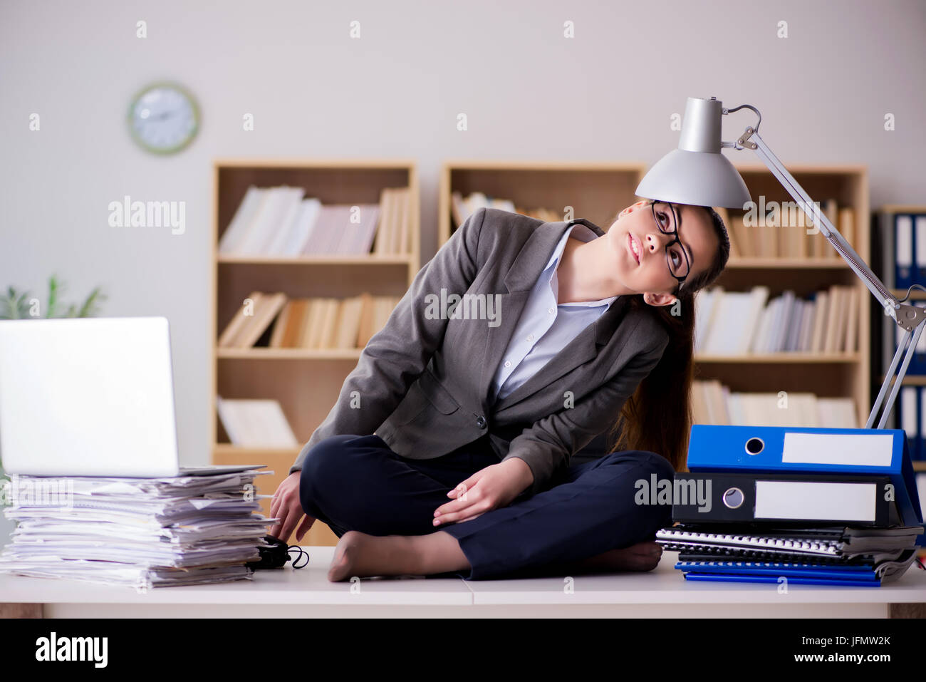 Busy angry businesswoman sitting on the desk in office Stock Photo - Alamy